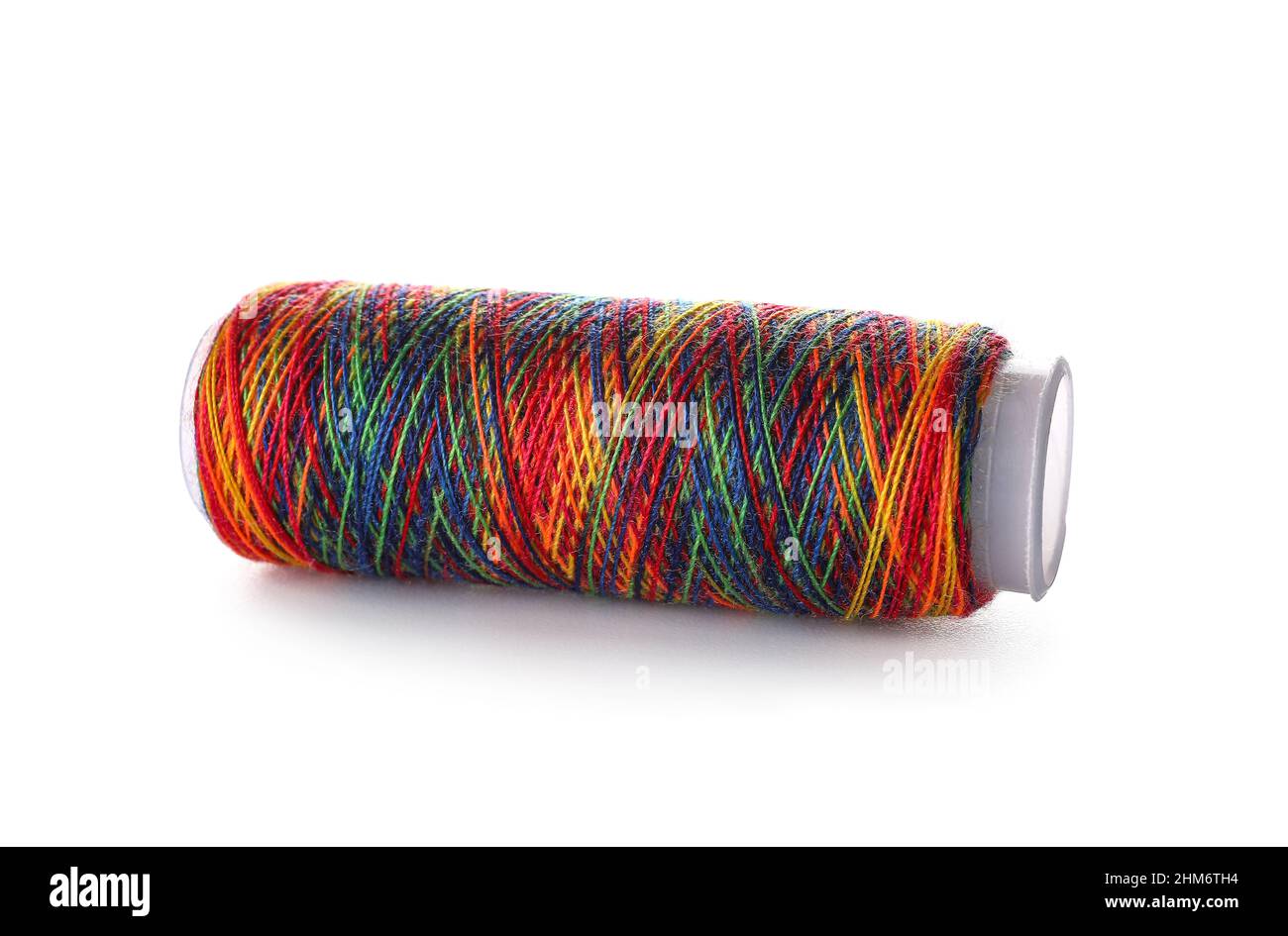 Rainbow sewing thread spool on white background Stock Photo - Alamy