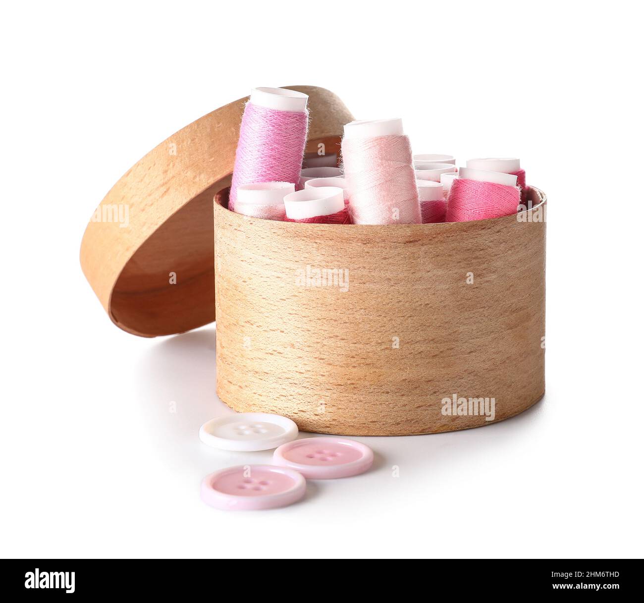 Wooden box with different sewing thread spools on white background ...