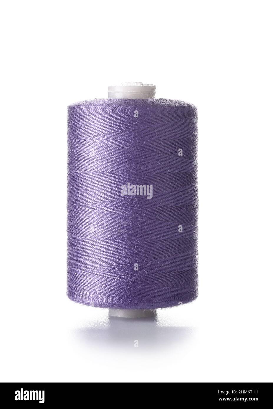 Purple sewing thread spool on white background Stock Photo - Alamy