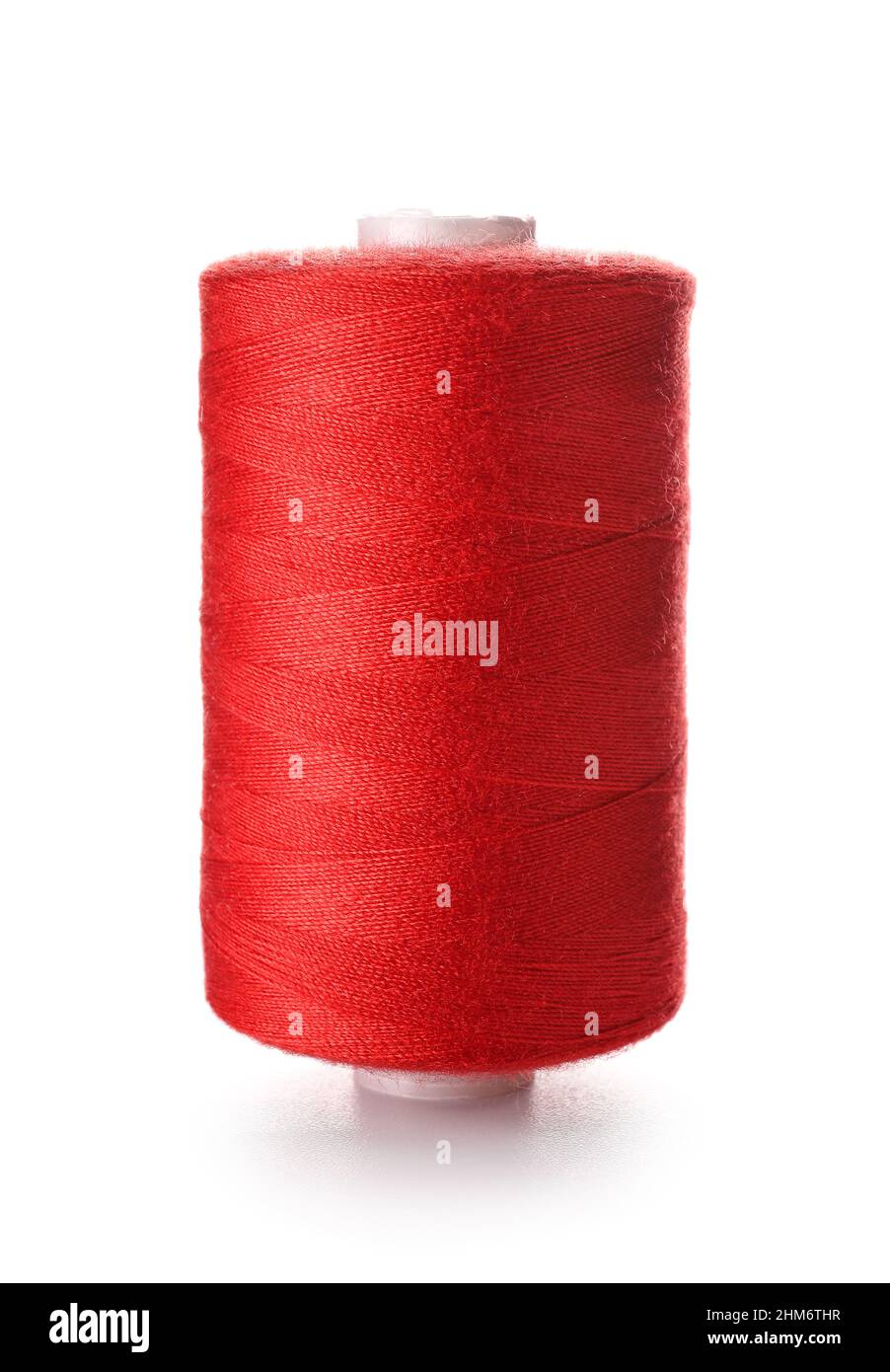 Red sewing thread spool on white background Stock Photo - Alamy