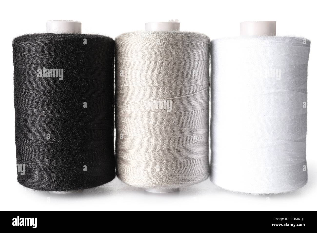 Multicolored sewing thread spools on white background Stock Photo - Alamy