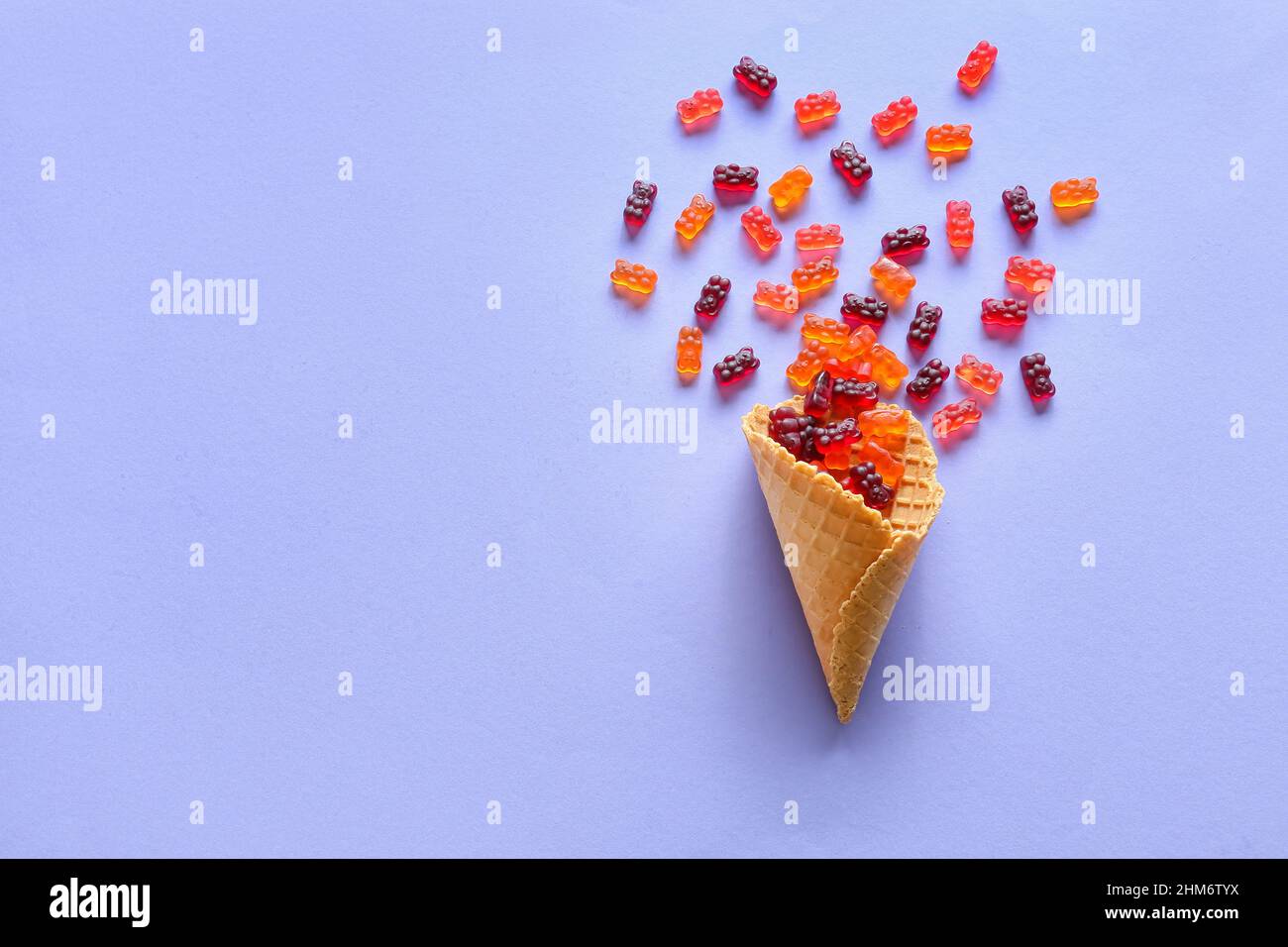 Wafer cone with sweet jelly bears on blue background Stock Photo - Alamy