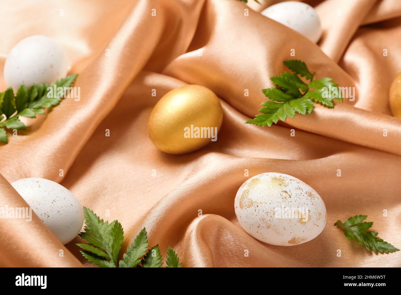 Beautiful Easter eggs and fern leaves on fabric background Stock Photo ...