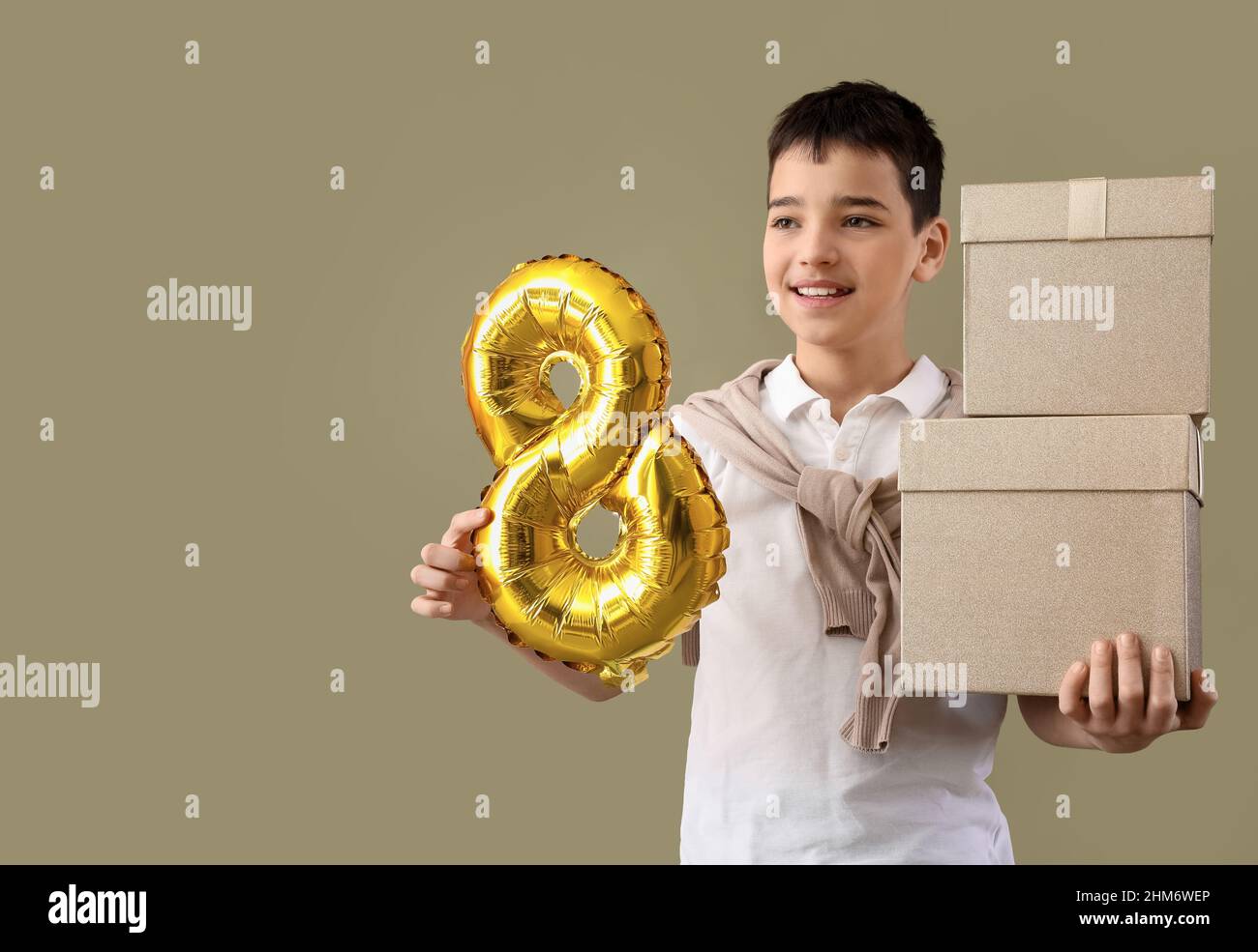 Little boy with balloon in shape of figure 8 and gift boxes on color ...