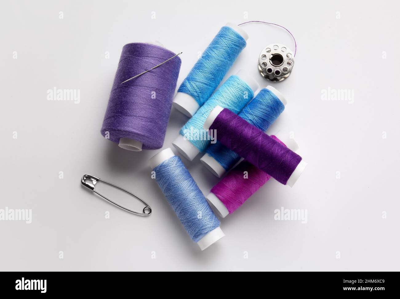 Thread spools and pin on white background Stock Photo - Alamy