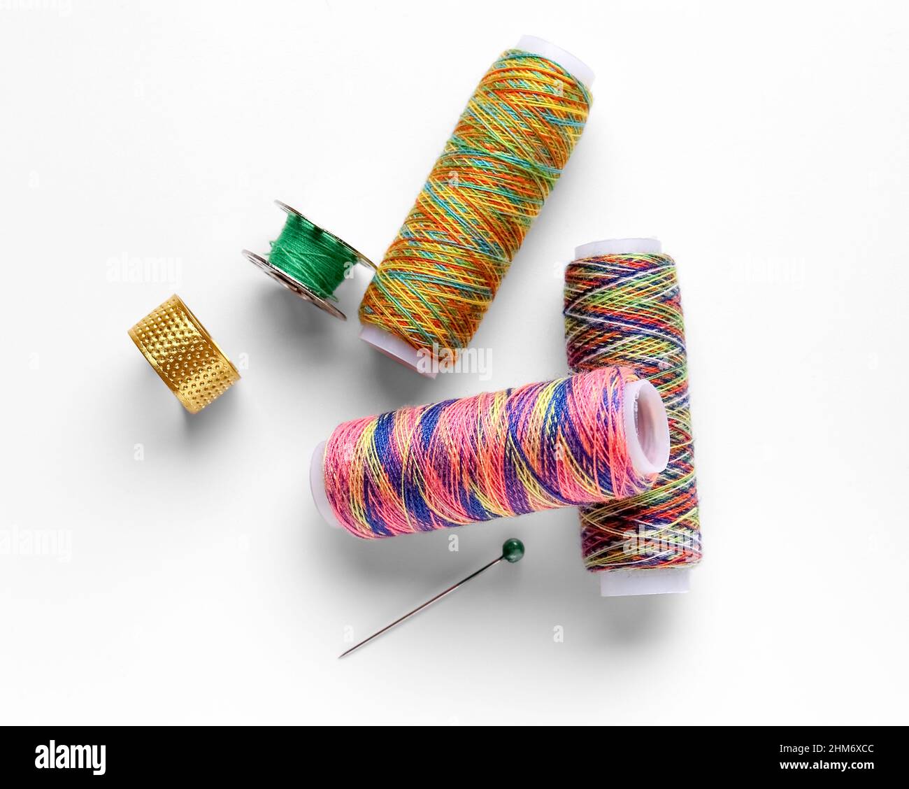 Thread spools and needle on white background Stock Photo - Alamy
