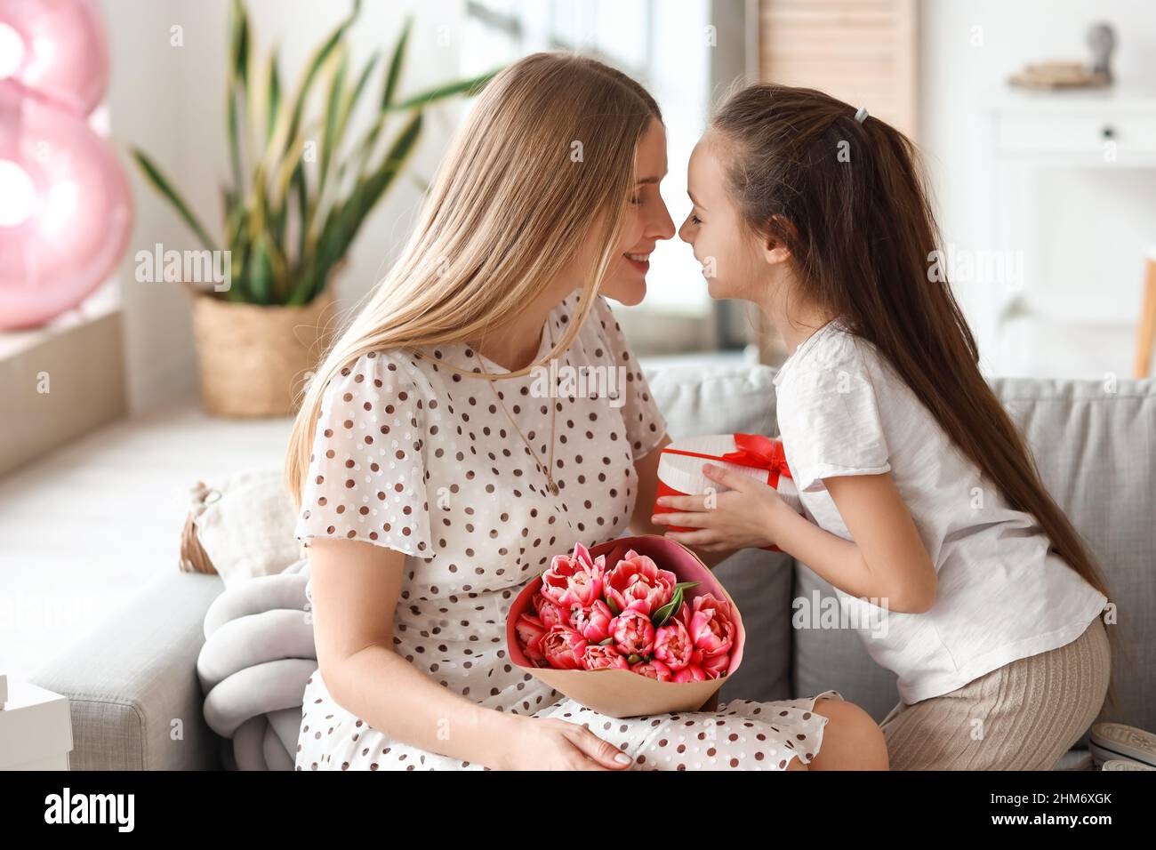 Little girl greeting her mother with gift at home on International ...