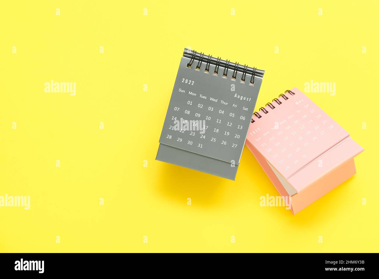 Paper calendars on yellow background Stock Photo - Alamy
