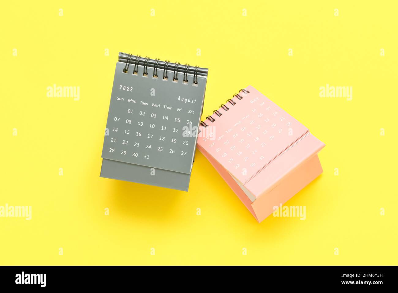Paper calendars on yellow background Stock Photo - Alamy