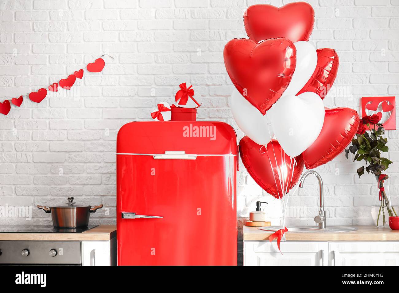 Red fridge, counters with stylish decor and heart shaped air balloons ...
