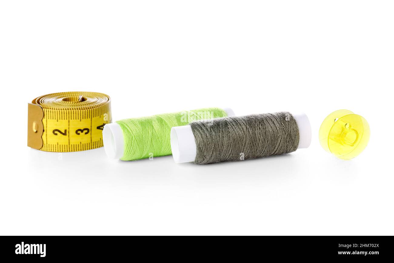 Thread spools and measuring tape on white background Stock Photo - Alamy
