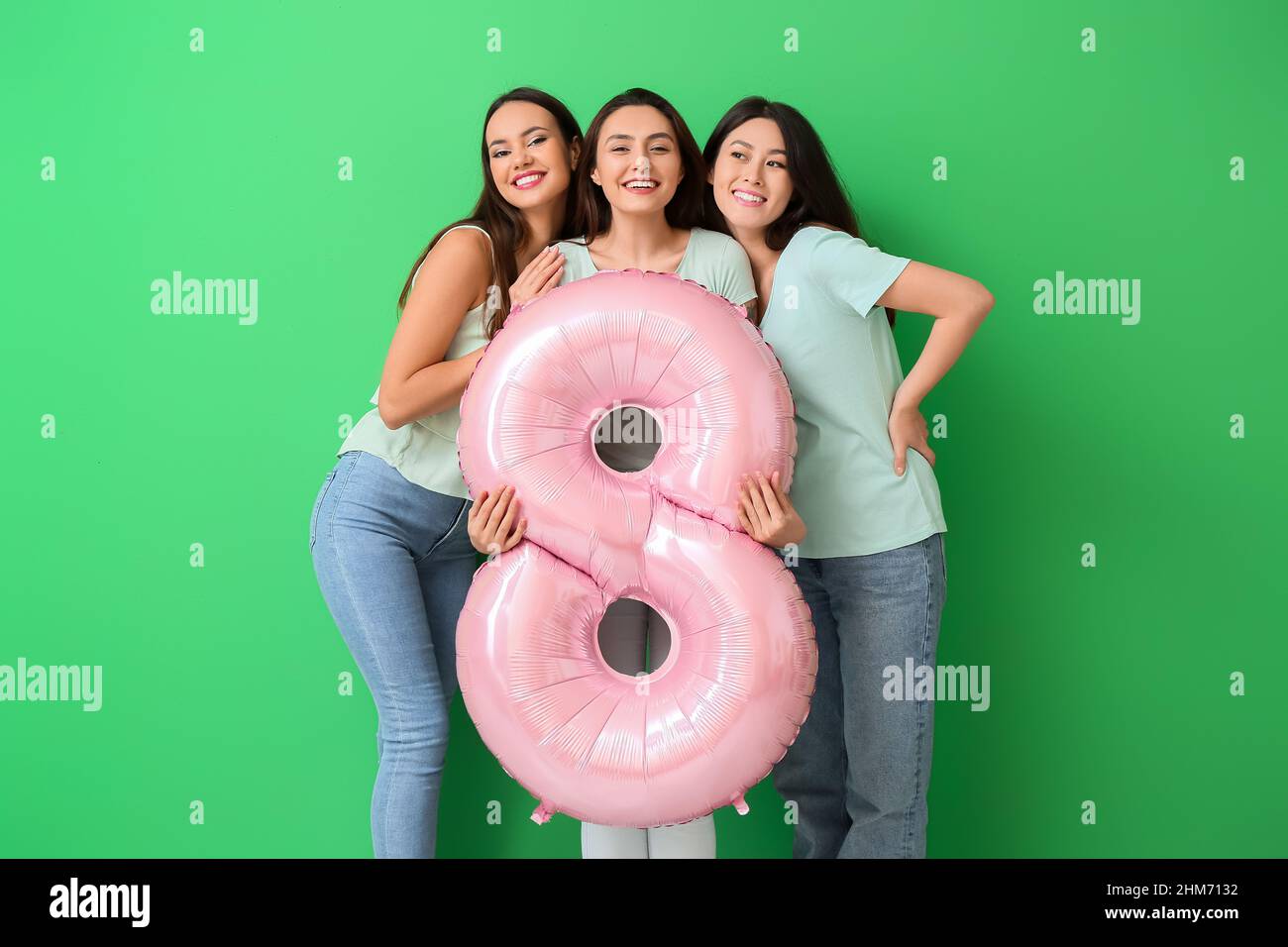 Beautiful women with balloon in shape of figure 8 on green background ...