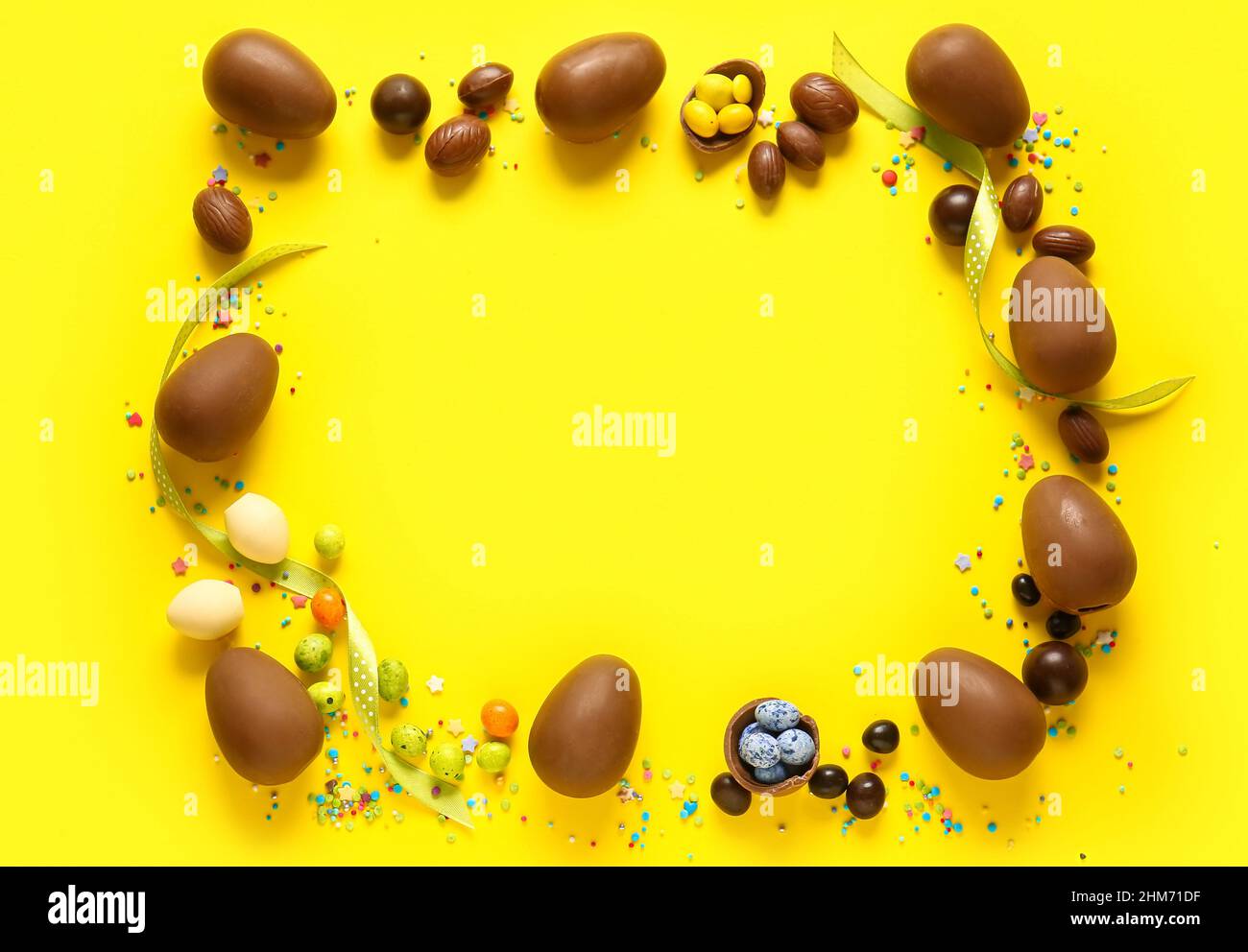 Frame made of chocolate Easter eggs, different candies and sprinkles on ...