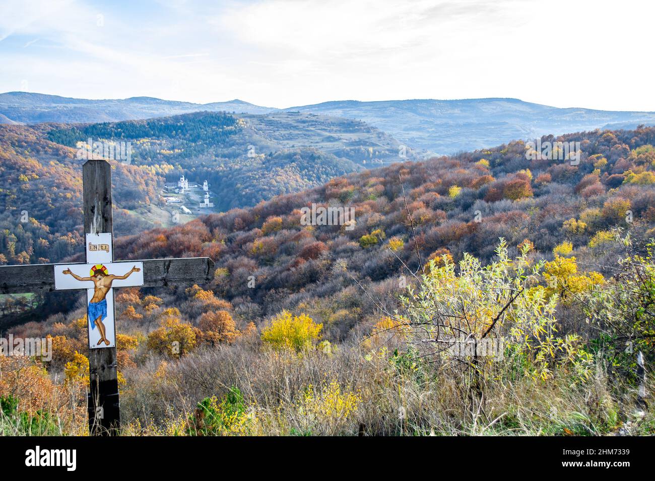 Wooden cross in a rural area with colorful forests in the background ...