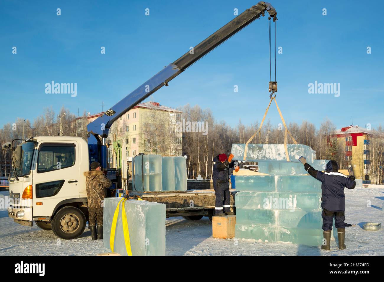 Assemblers unload ice panels from a car using a crane Stock Photo - Alamy