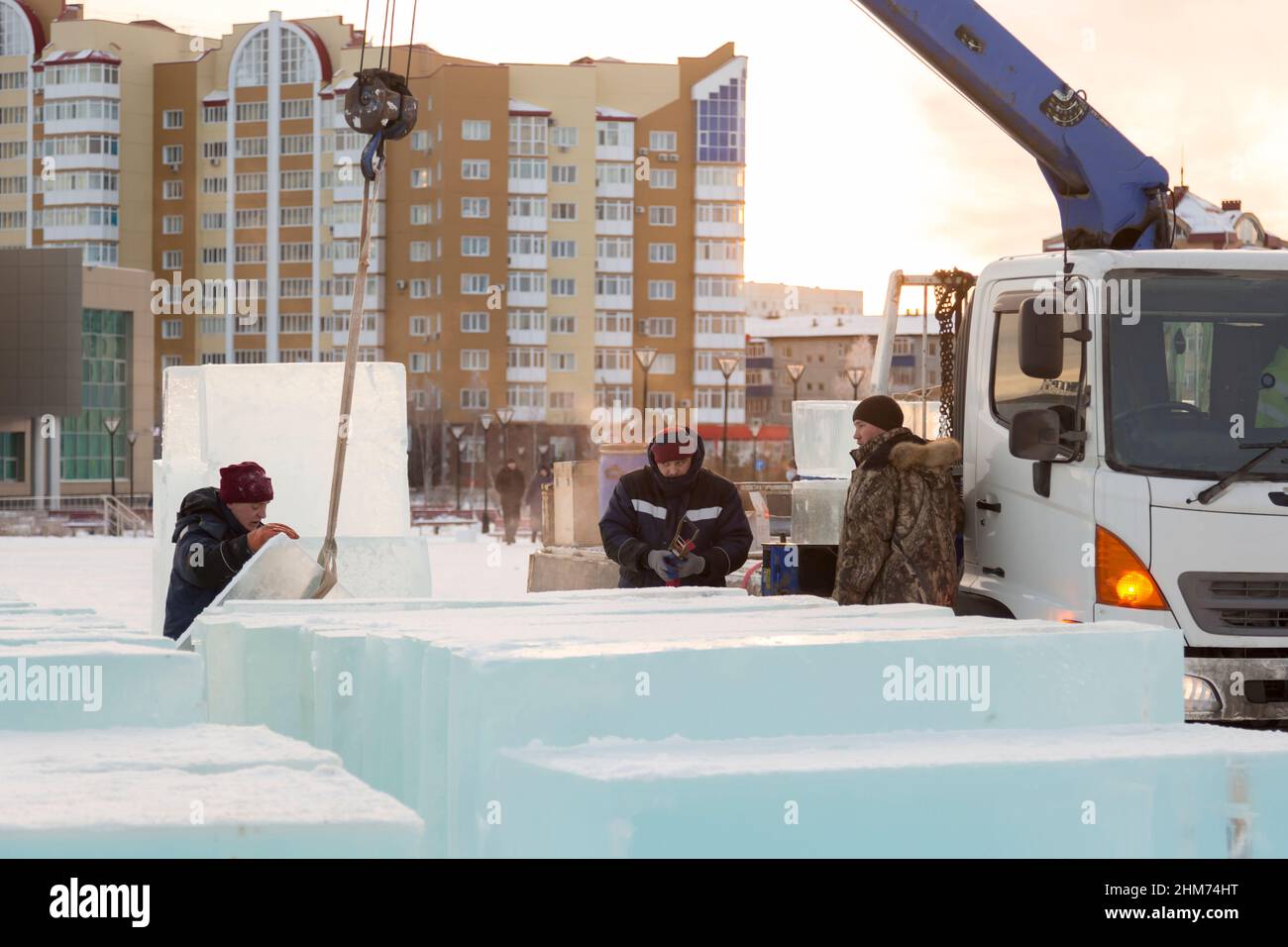 Three assembly workers stacking ice slabs on a construction site Stock ...