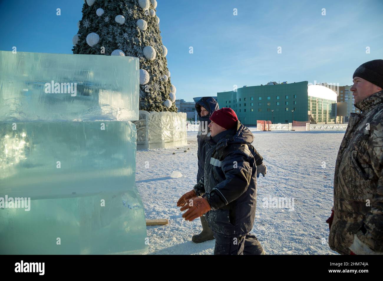 Three assembly workers stacking ice slabs on a construction site Stock ...