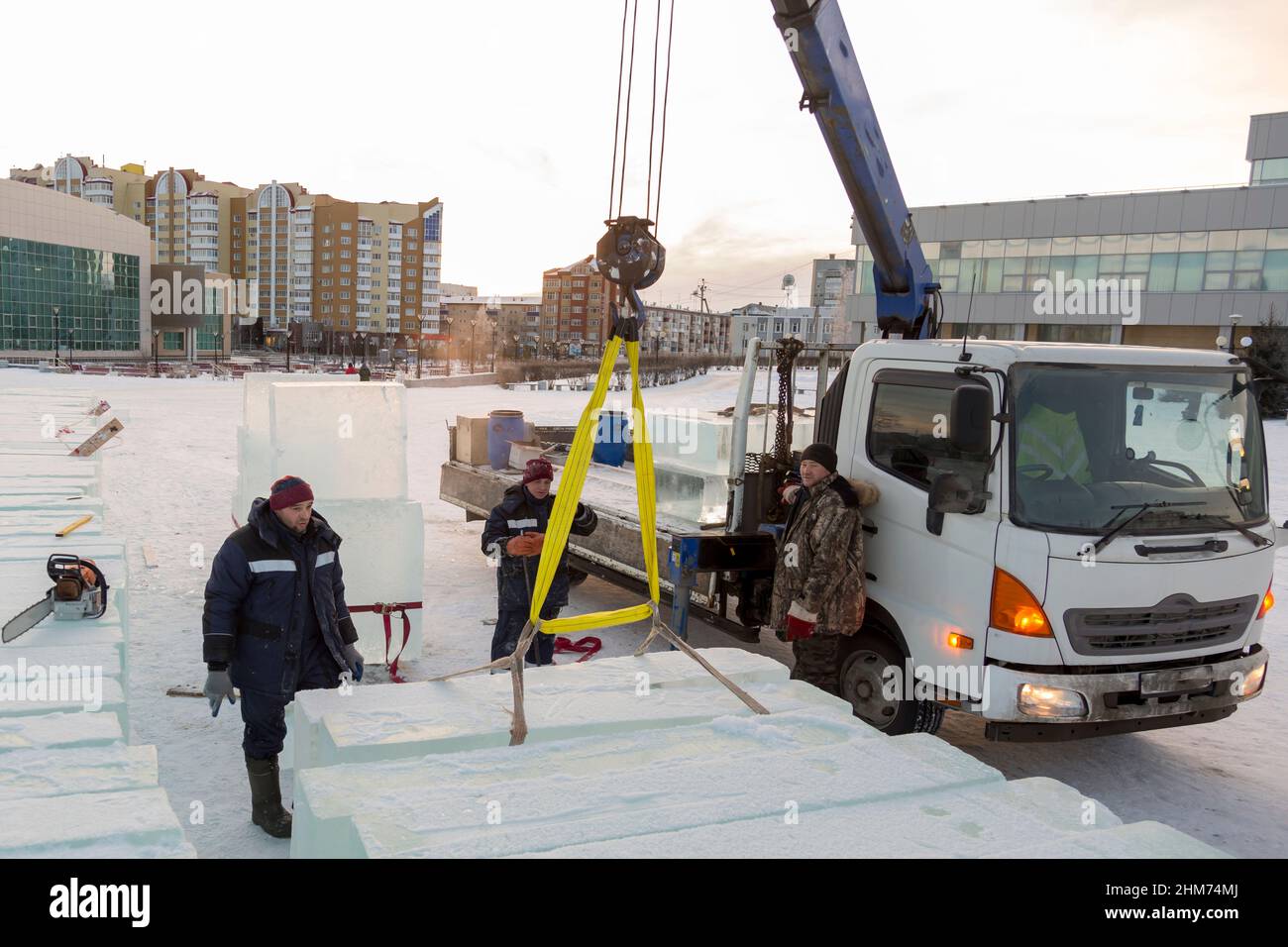 Three assembly workers stacking ice slabs on a construction site Stock ...