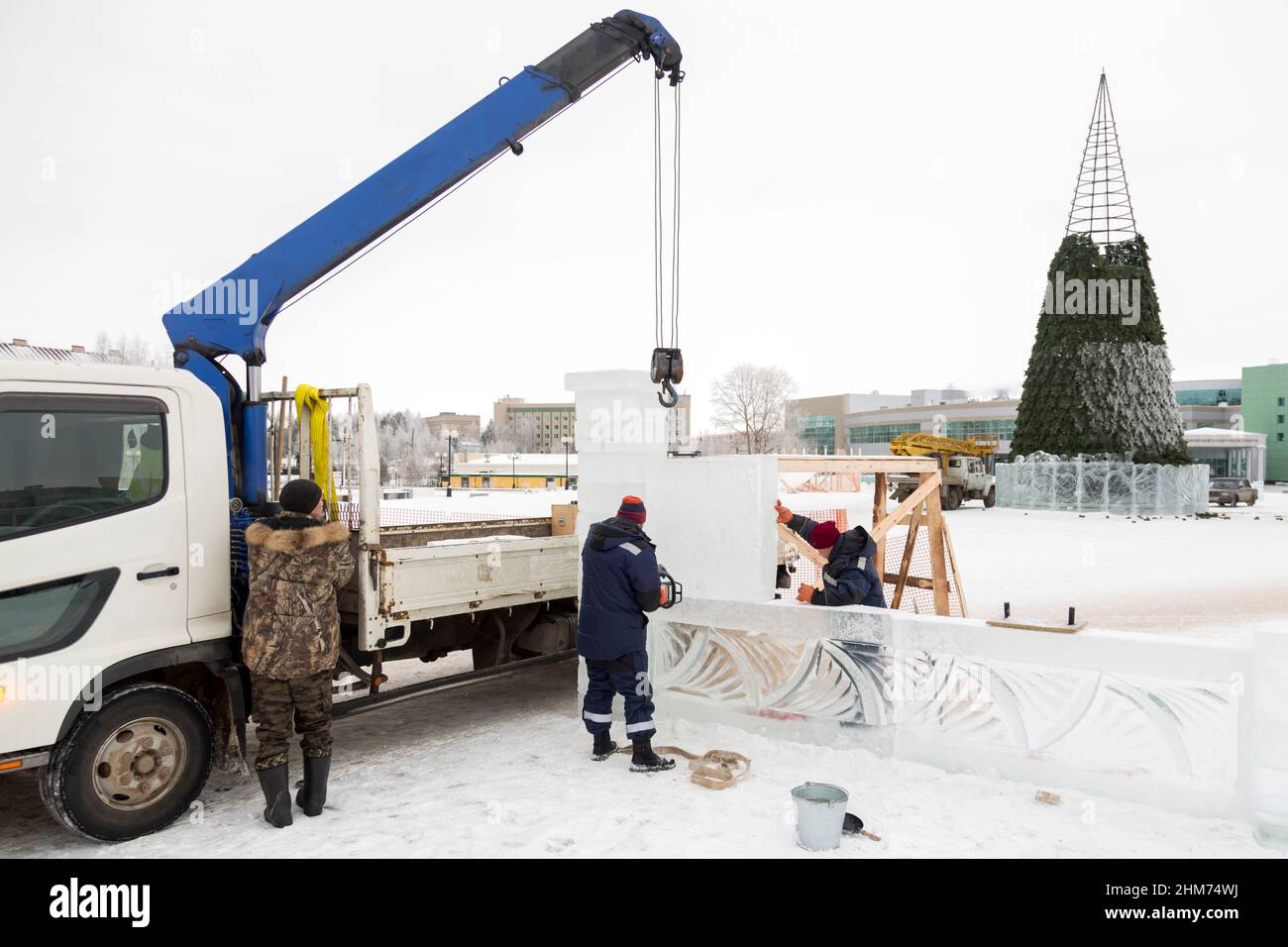 Three workers at the installation site of the ice town on the ...
