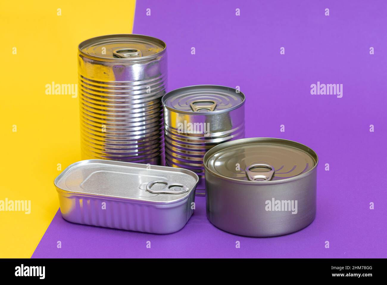 A Group of Stacked Tin Cans with Blank Edges on Split Yellow and Violet ...