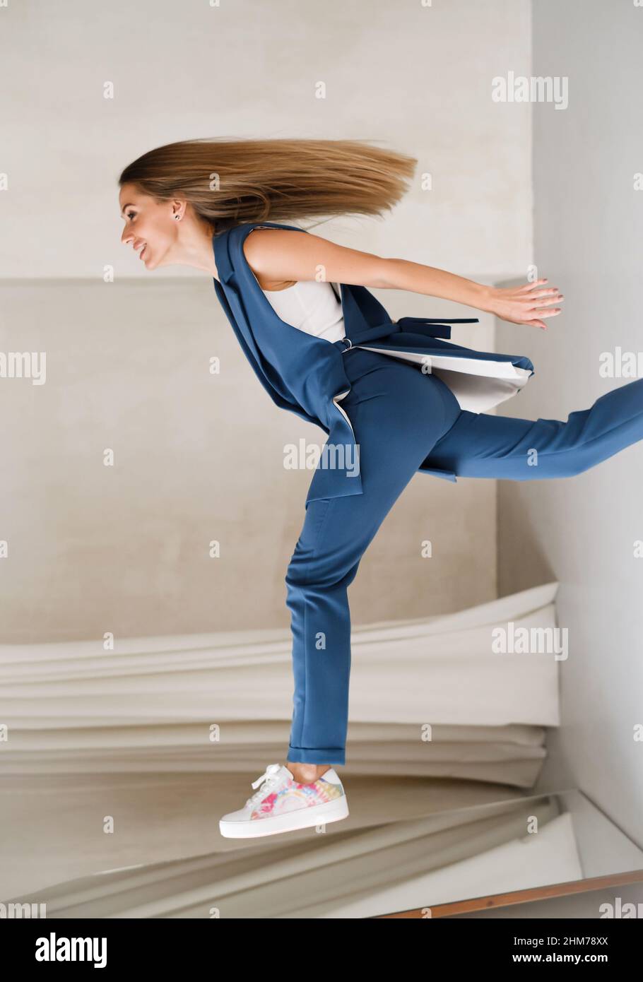 Creative balancing young woman ready to step or fall. Happy in business ...