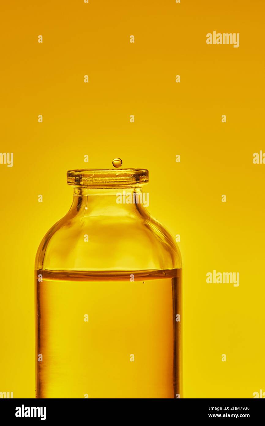 Bottle of cosmetic oil. A flying drop of oil. Front view Stock Photo ...