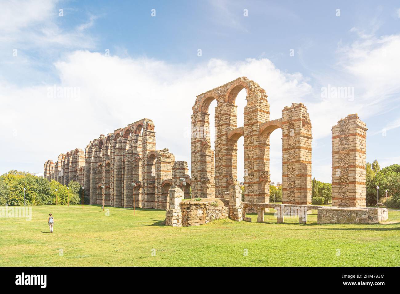 Traveler on green grass against ancient Roman ruins Stock Photo - Alamy