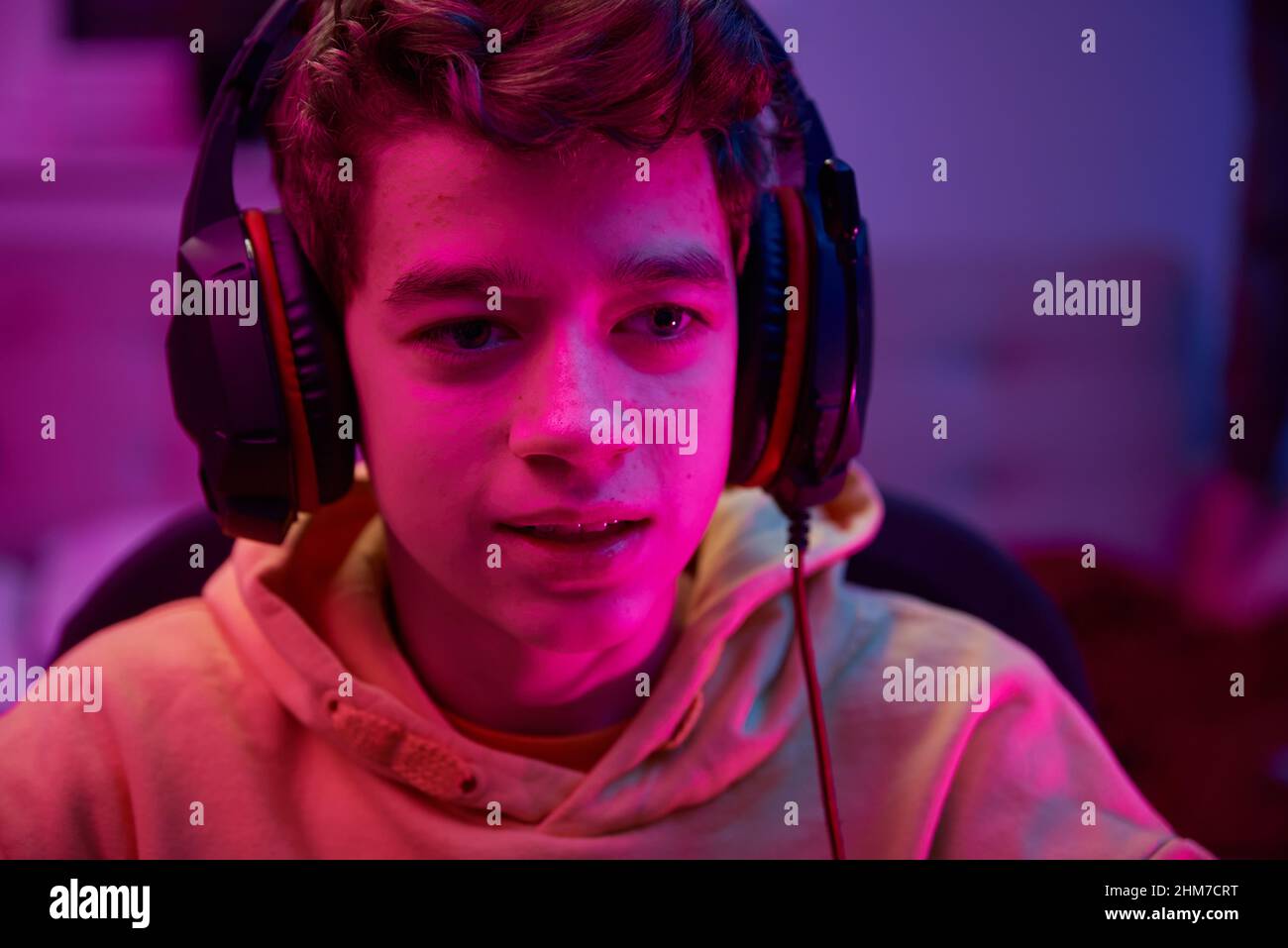 Portrait of teenager boy playing computer video game in dark room ...