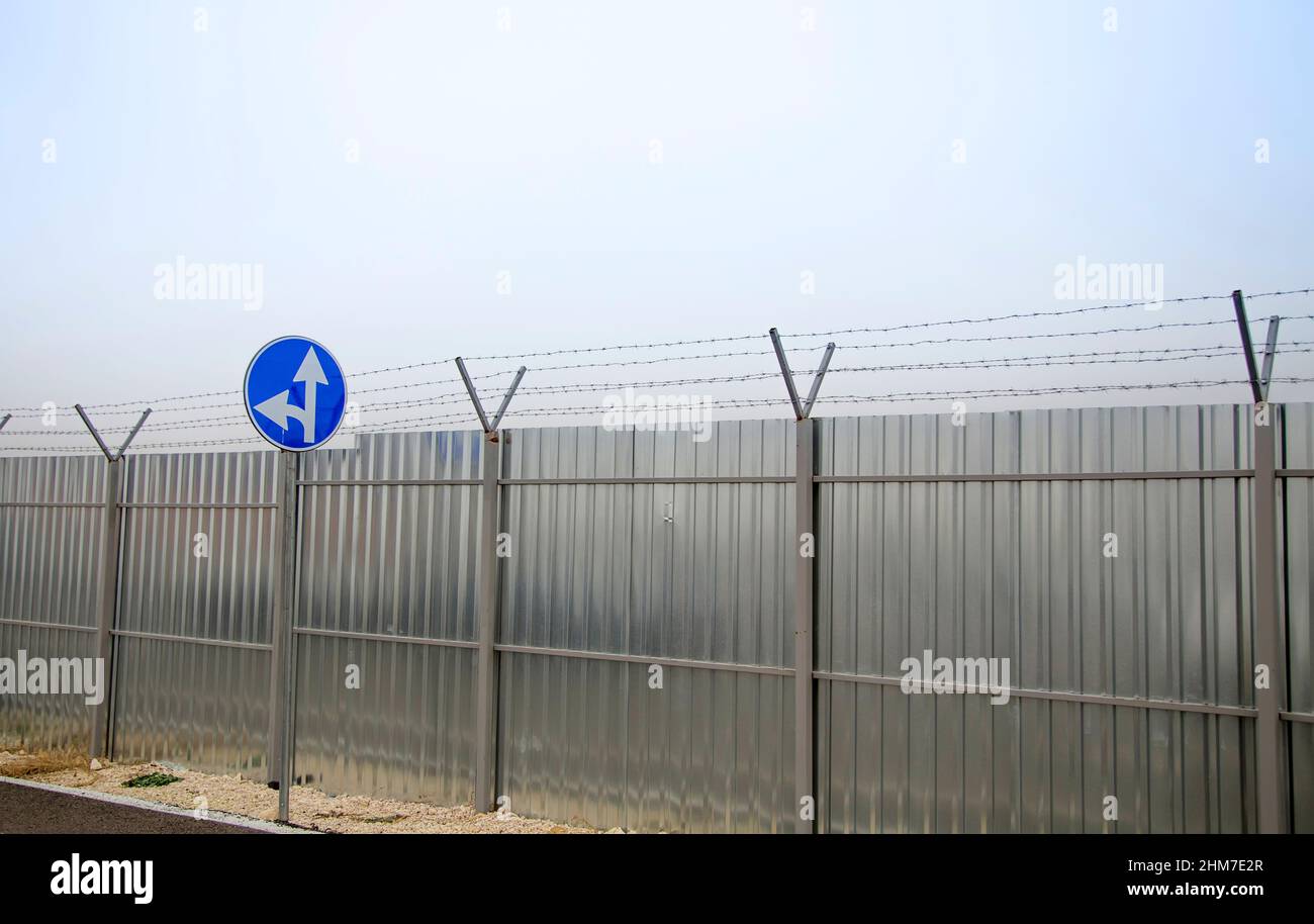 A closeup of straight and left turn arrow sign at the perimeter with ...