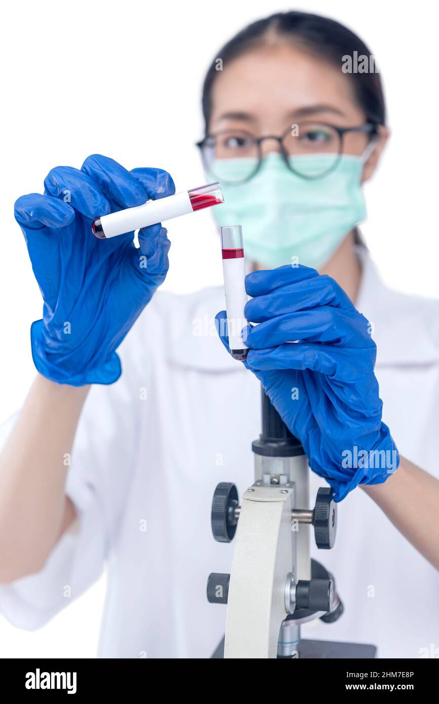 Asian researcher woman with face mask and glasses holding medical tube ...