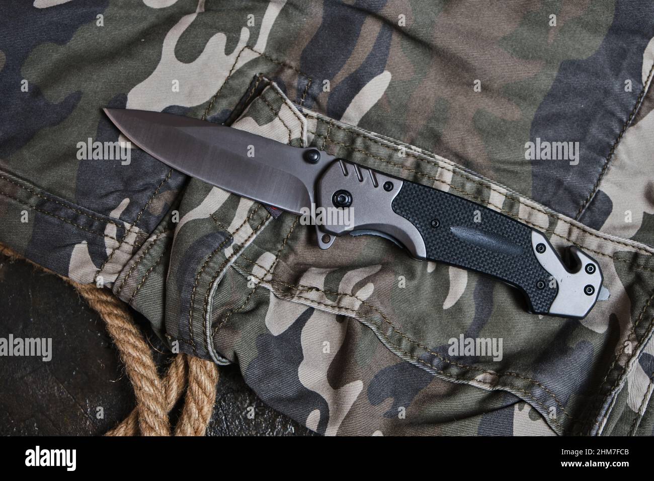 Tactical folding knife for survival and rope on camouflage military ...