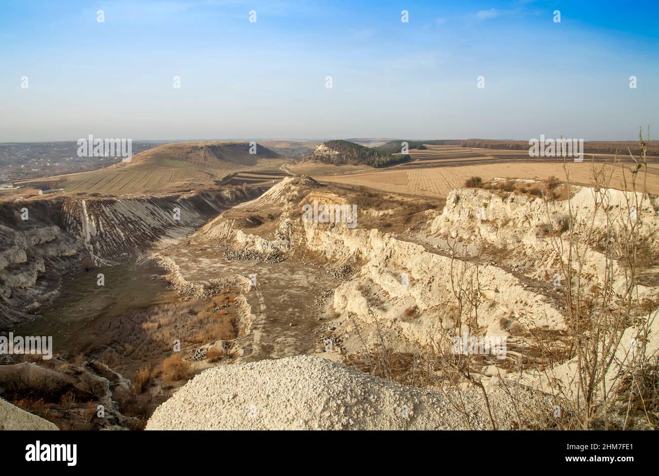 A view on hills and fields from a limestone cliff at a quarry under a ...