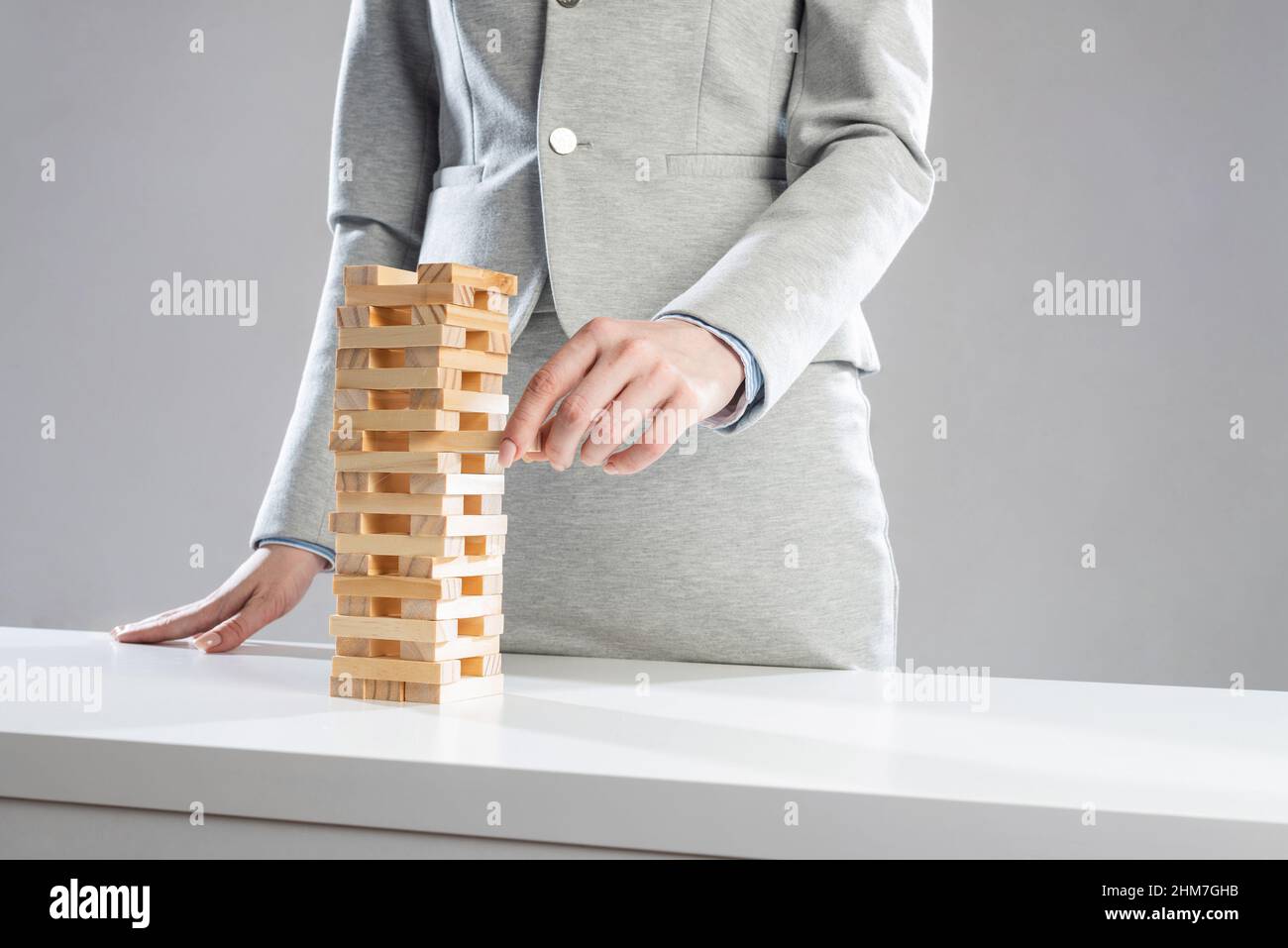 Business woman building tower from wooden blocks Stock Photo - Alamy