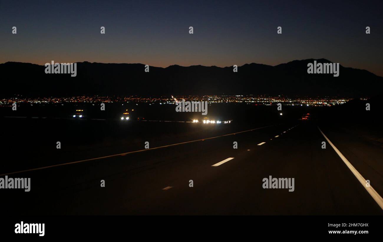 Car driving on desert road at night, freeway or highway in twilight ...