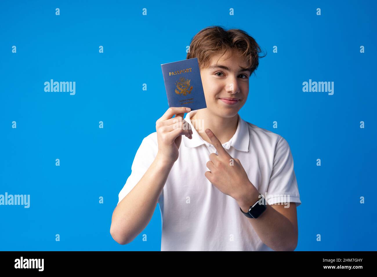 Portrait of glad handsome boy showing his passport going on vacation ...