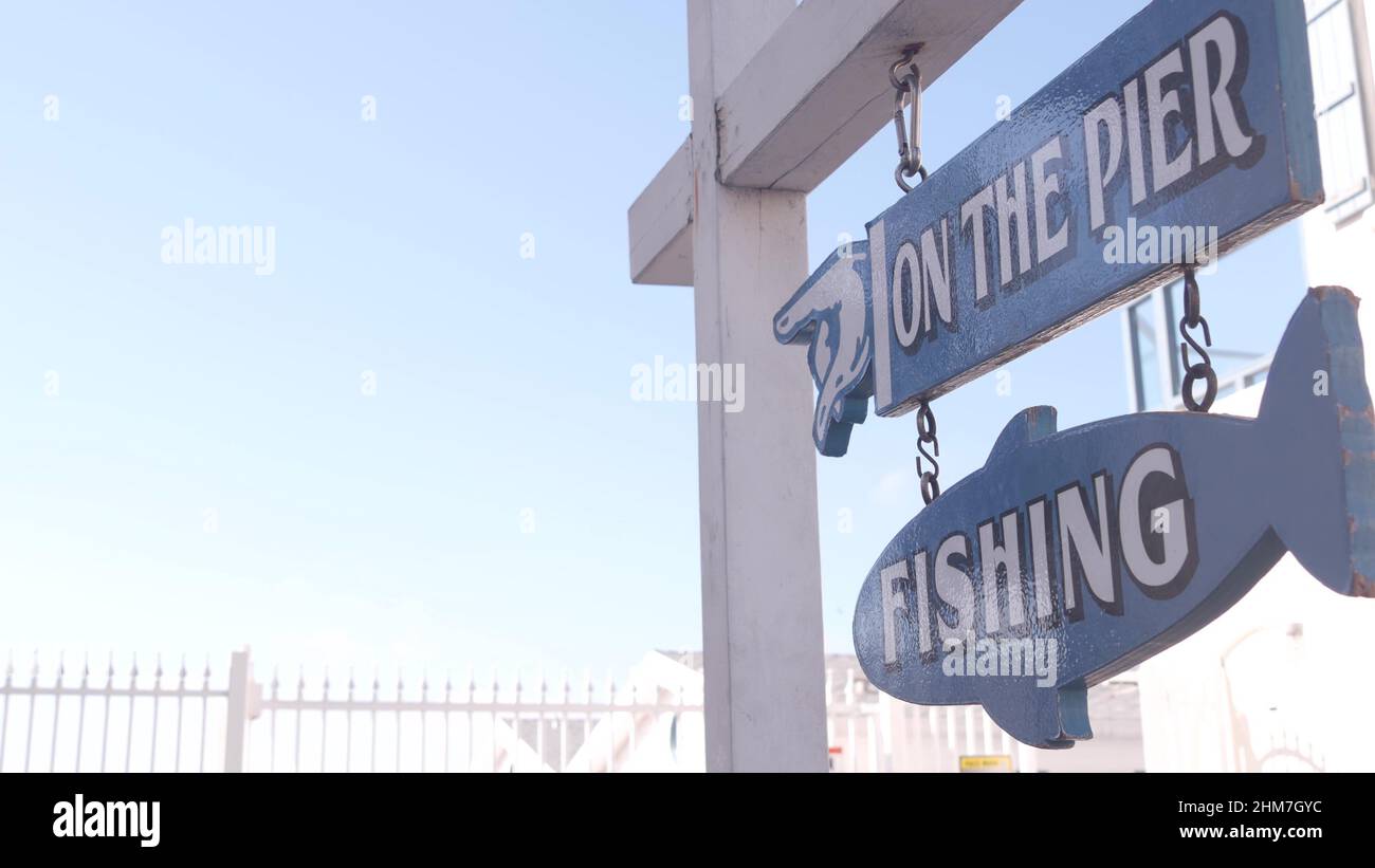Fishing on pier wooden blue sign, California ocean beach, USA. Coast ...