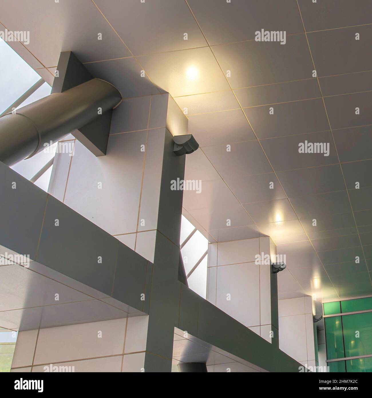 Square Light gray ceiling tiles and columns inside a building at Salt ...