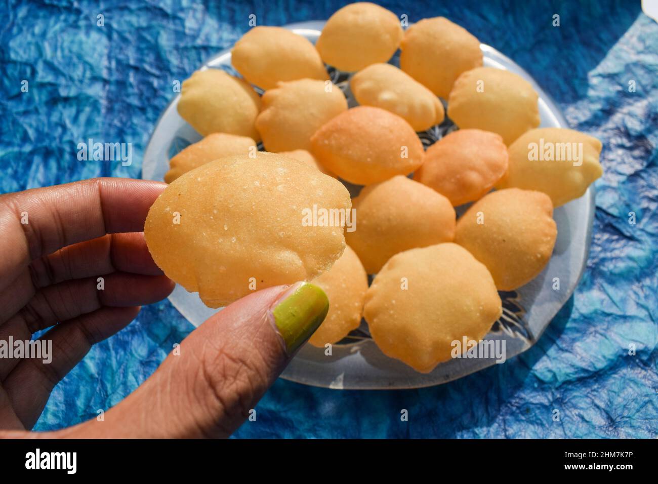 Female holding eating Indian and Pakistani street food item Pani puri ...
