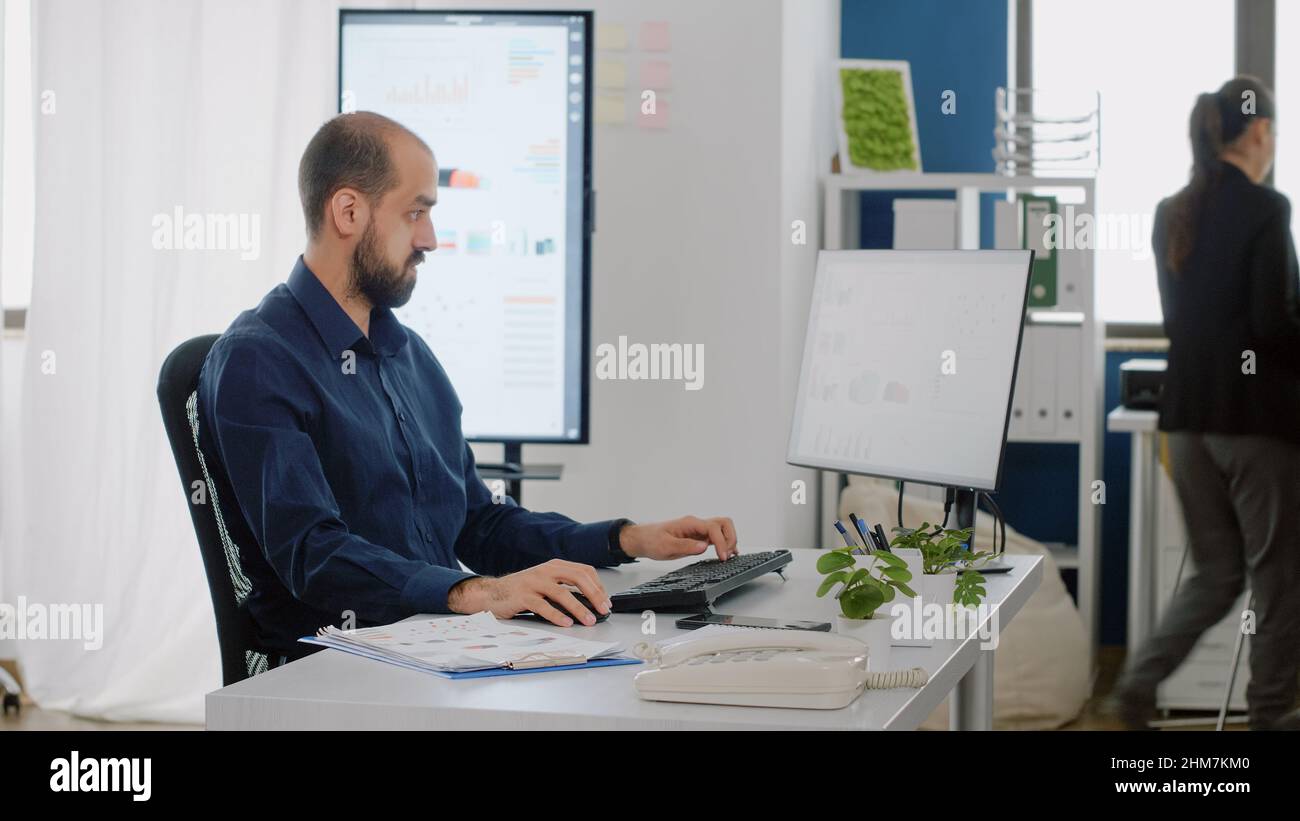 Businessman typing on keyboard for corporate work, using computer ...