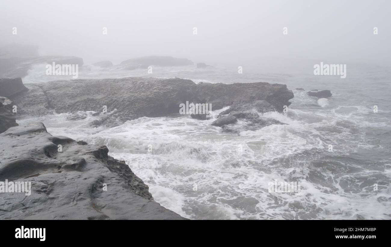 Foggy sea landscape, waves crashing on ocean beach in haze, misty ...
