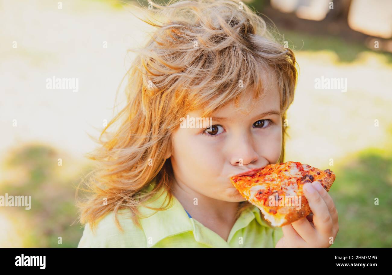 Boy kid enjoy eating pizza. Eatiing pizza outdoor Stock Photo - Alamy