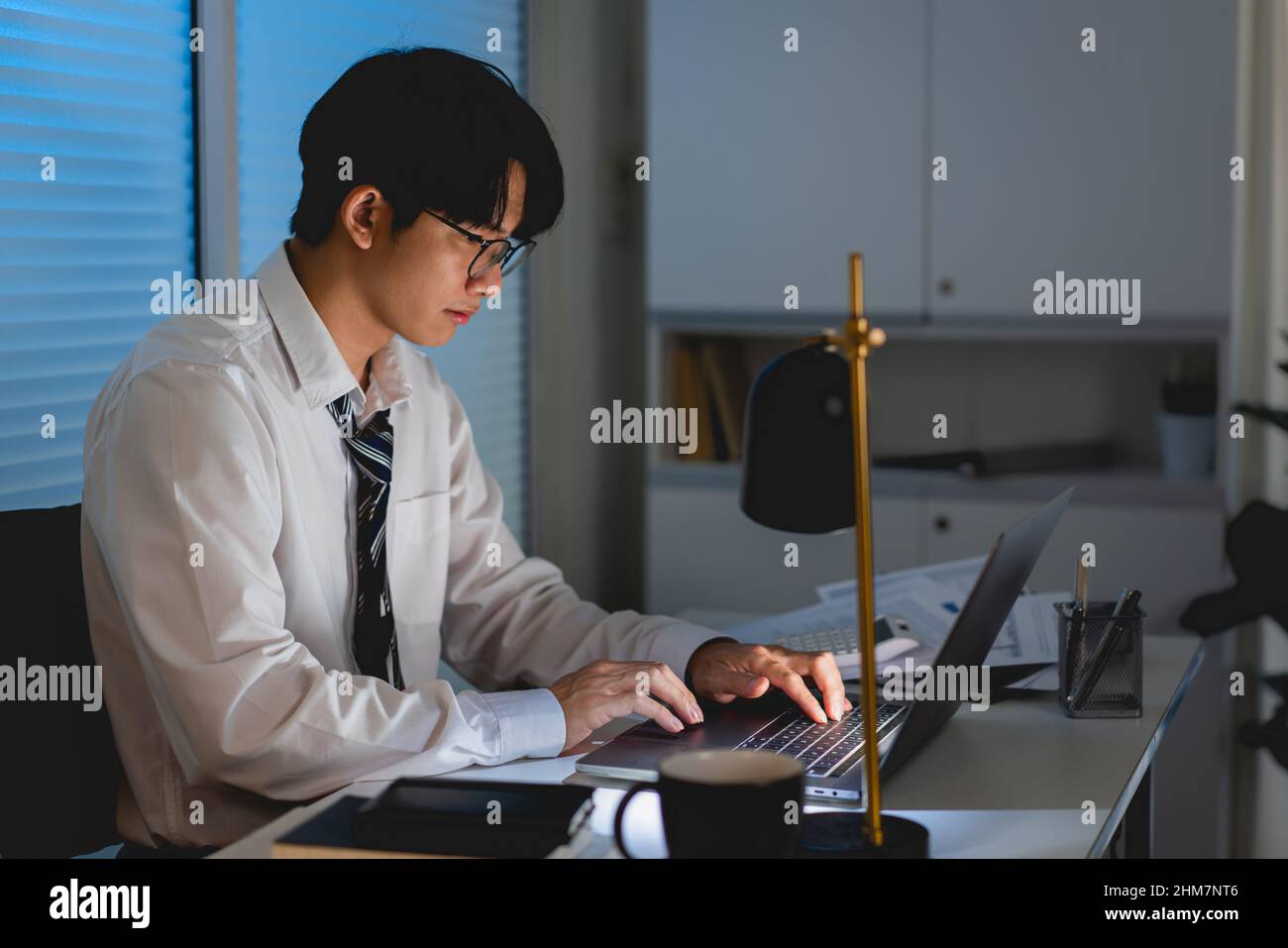 Overwork Concept The man sitting at his desk and focusing on working ...