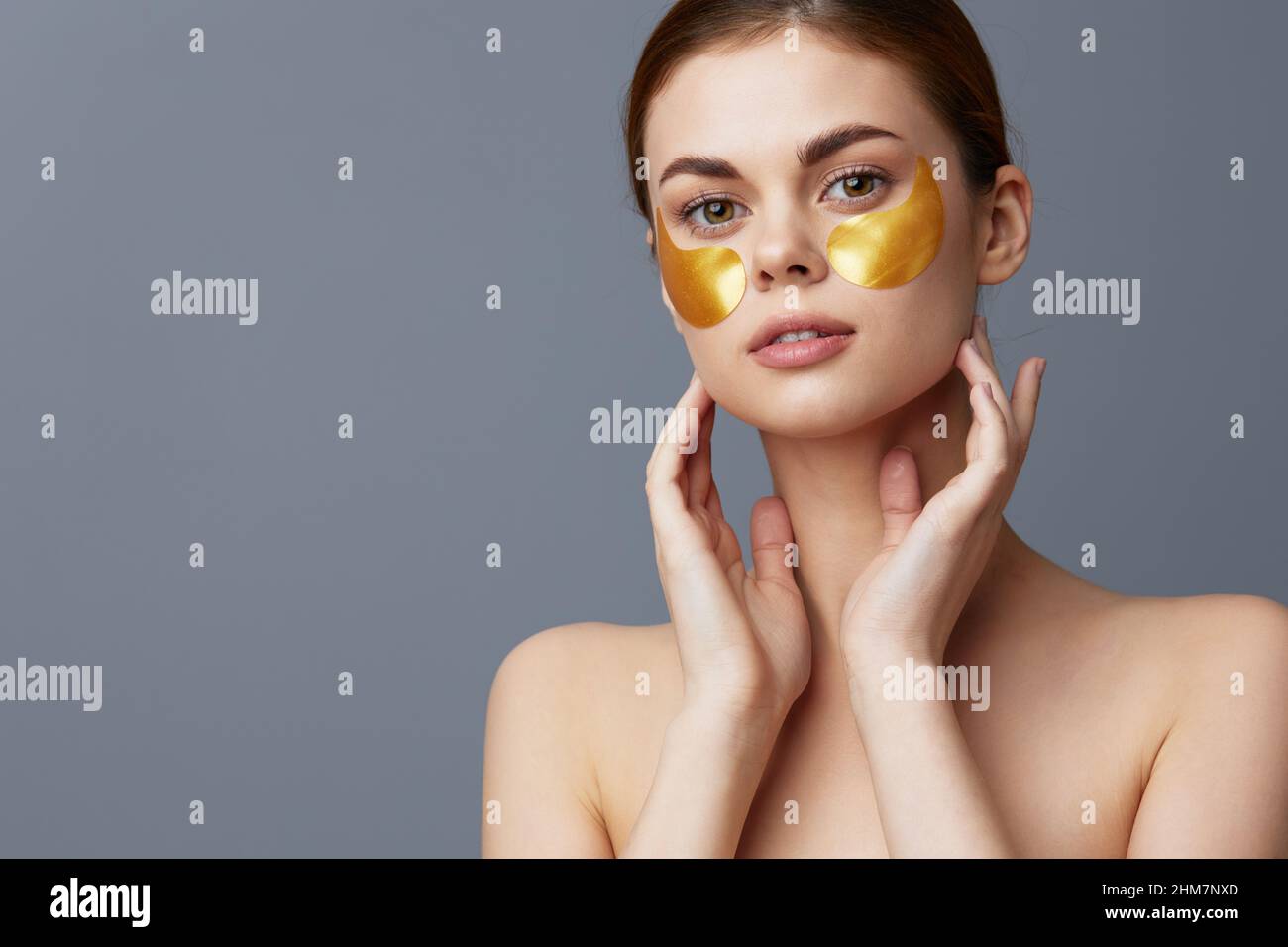 young woman golden patches on the face gray background Stock Photo - Alamy