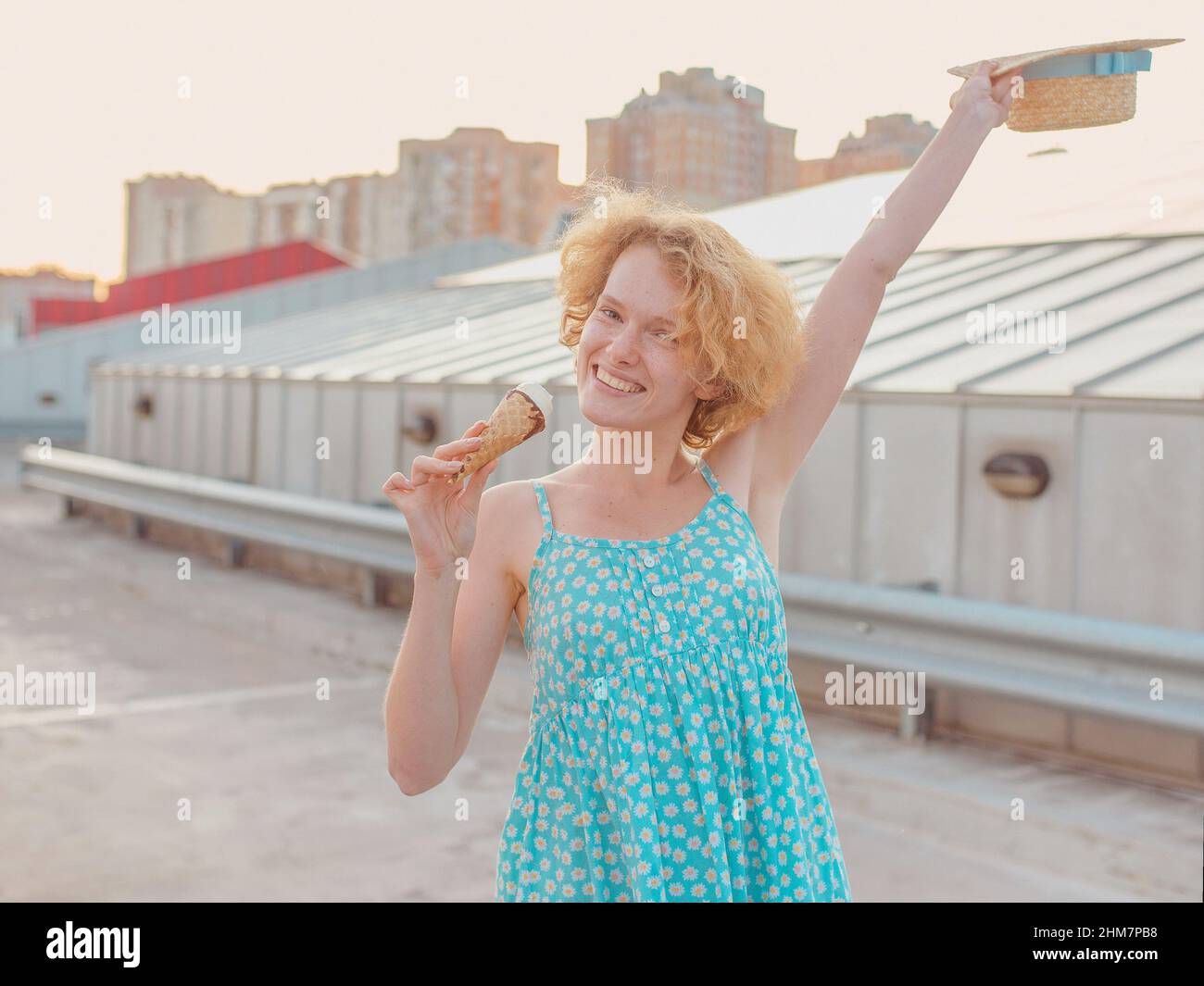 young happy cheerful curly redhead woman in straw hat, blue sundress ...