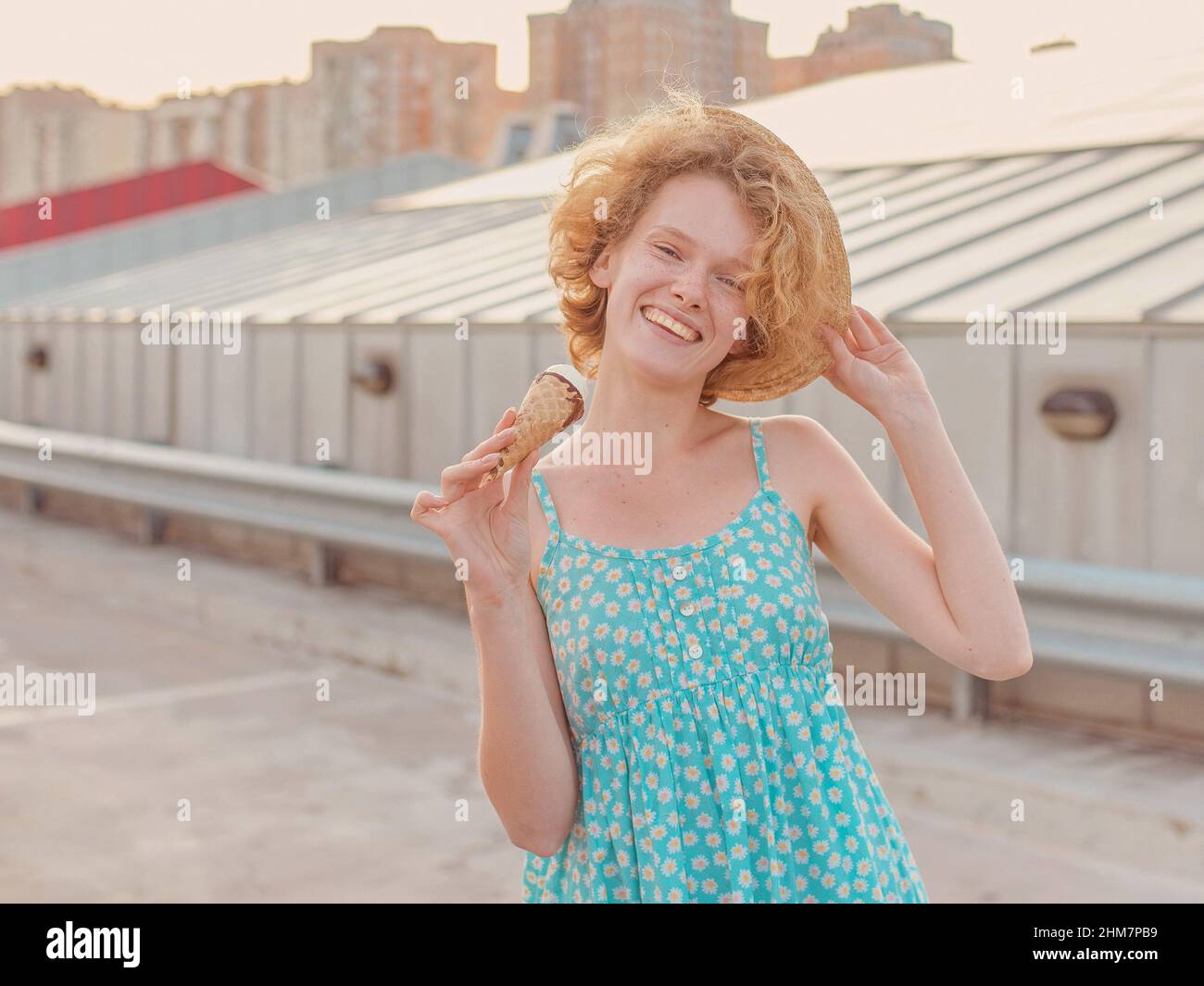 young happy cheerful curly redhead woman in straw hat, blue sundress ...