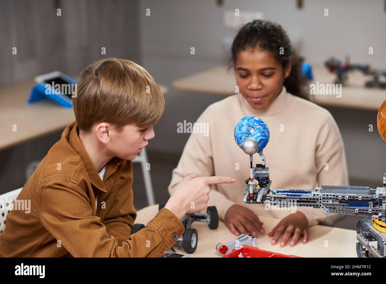 Two teenage kids building electric robots while enjoying engineering ...