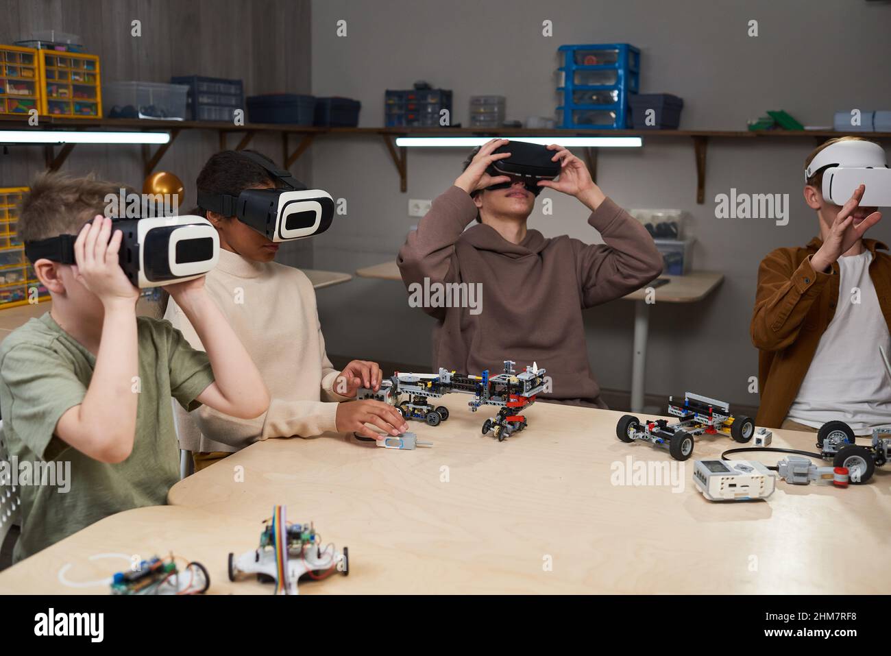 Diverse group of children wearing VR gear in school while sitting at ...