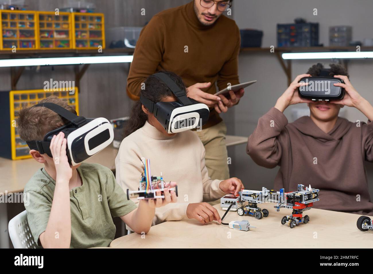 Diverse group of children wearing VR gear in school and using augmented ...