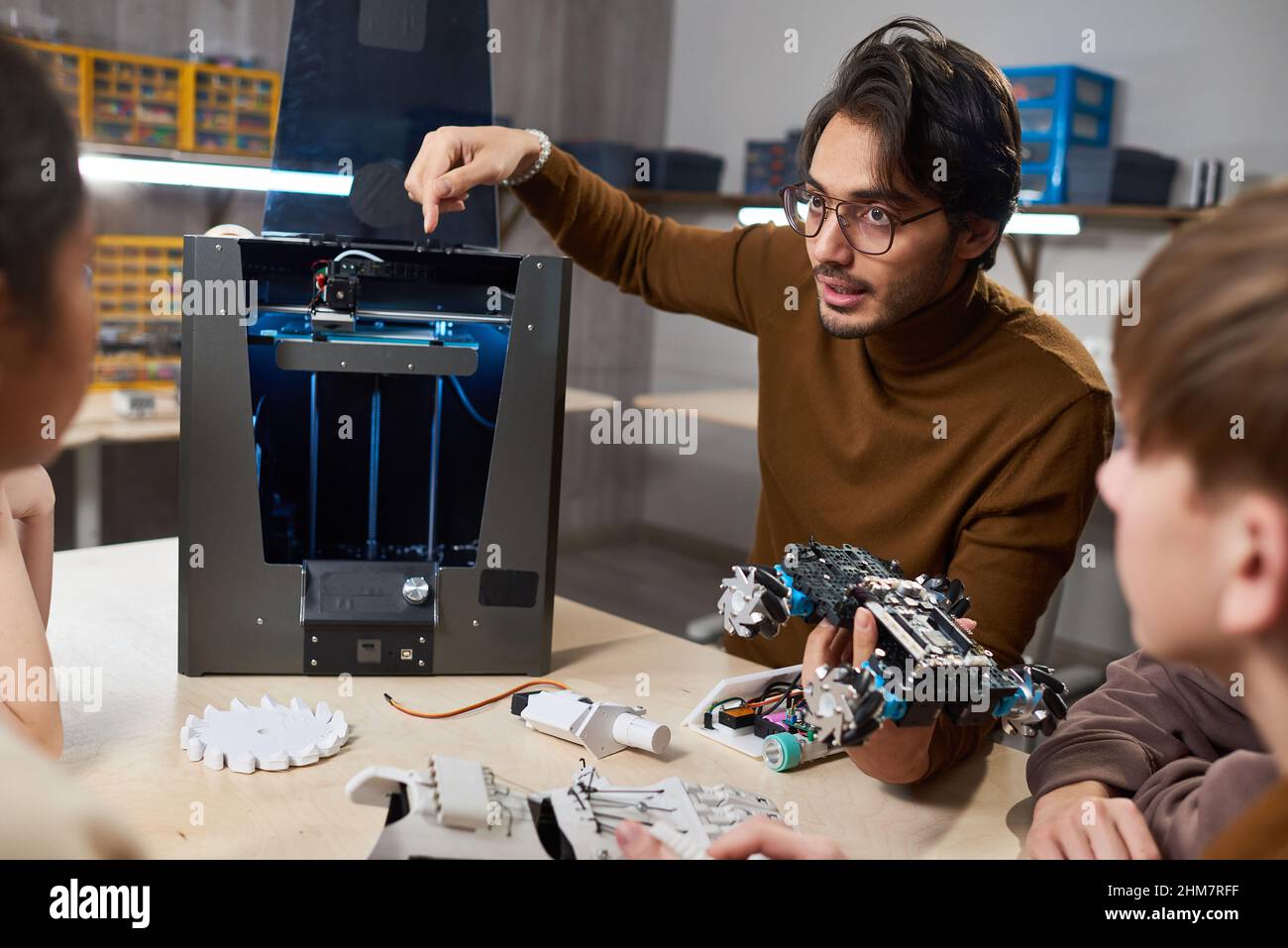 Portrait of young male teacher showing 3D printing technology to ...