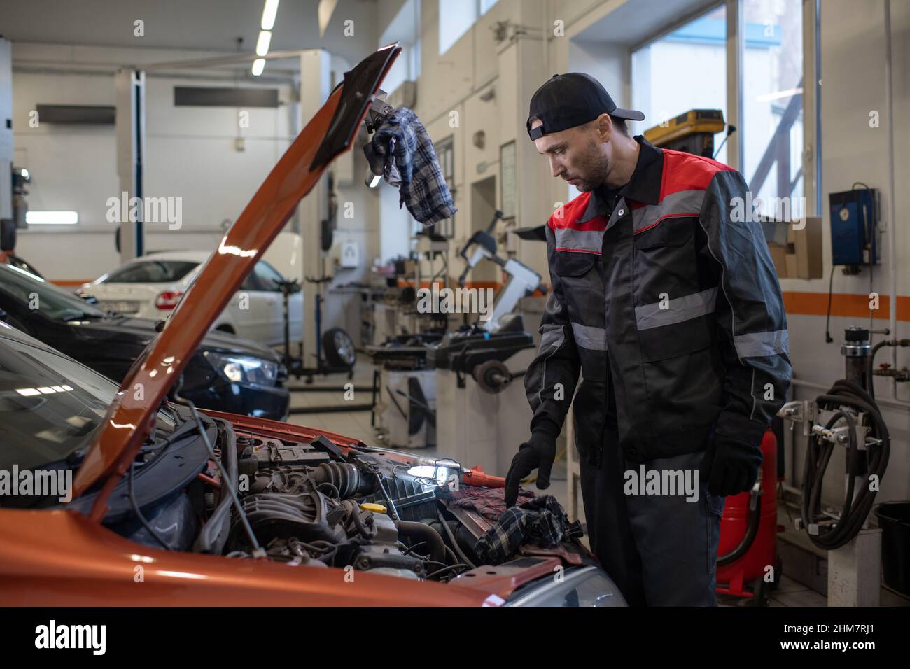 Side view portrait of male mechanic inspecting engine while working in ...